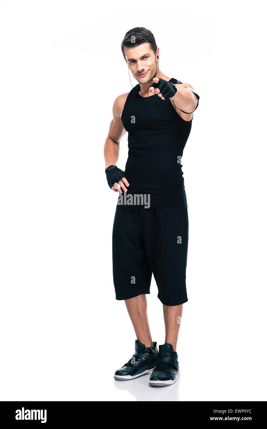 Full length portrait of a sports man pointing finger at camera isolated ...