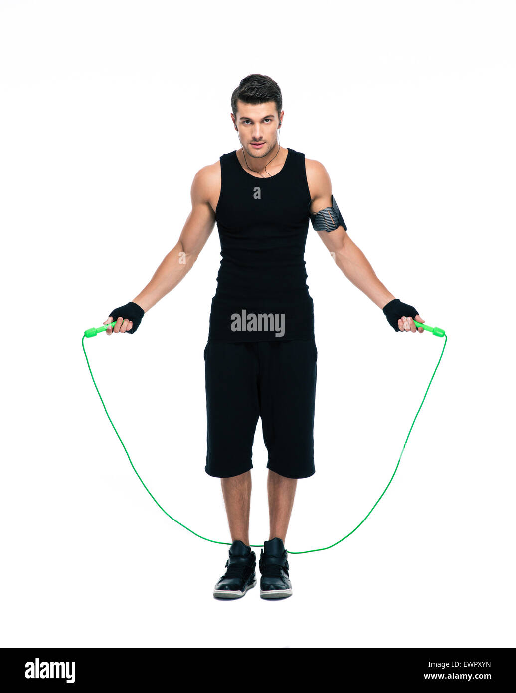 Full length portrait of a handsome man jumping with skipping rope ...
