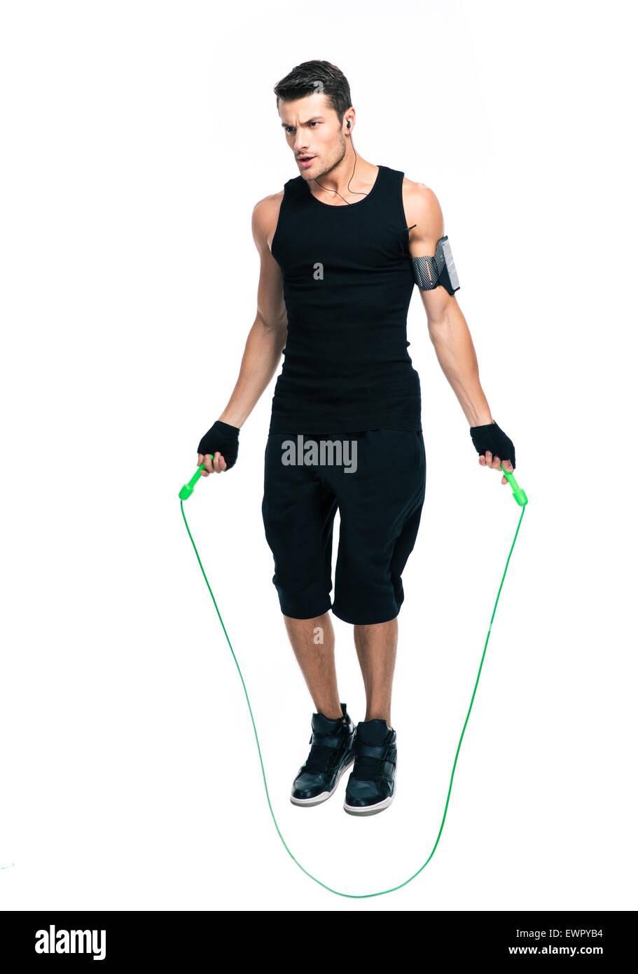 Full length portrait of a handsome man jumping with skipping rope ...