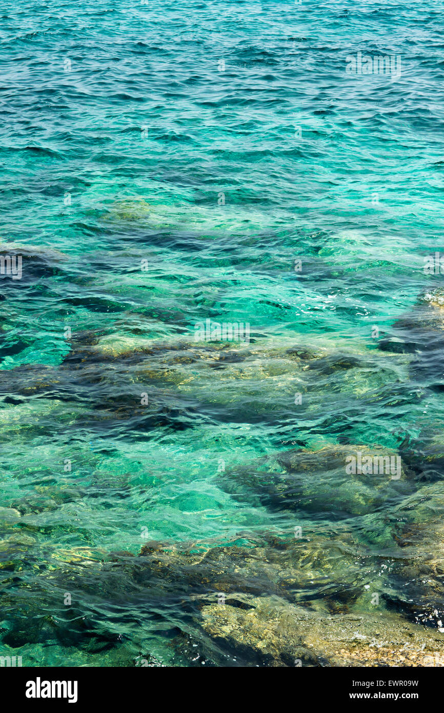transparent water ripple, marine rocks and sunlight glare. sea bottom ...