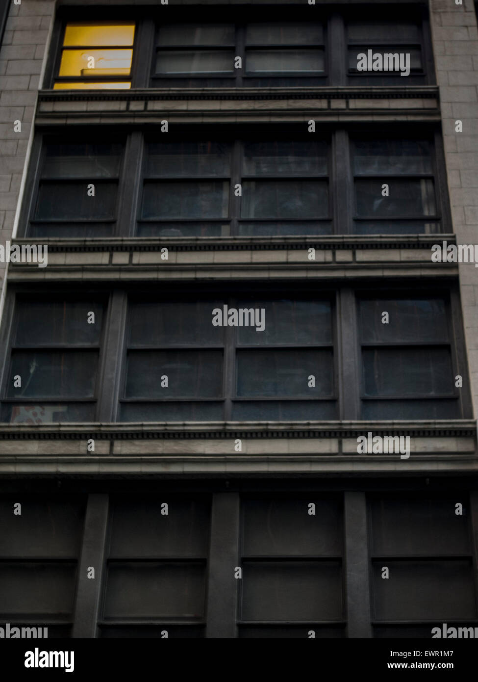 A single lit window in an otherwise totally dark building in Manhattan ...
