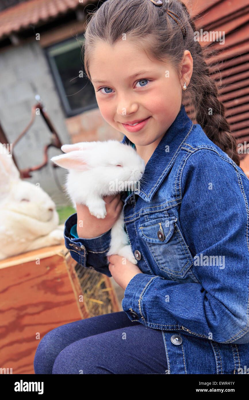 little girl with a rabbit in front of the farm Stock Photo - Alamy