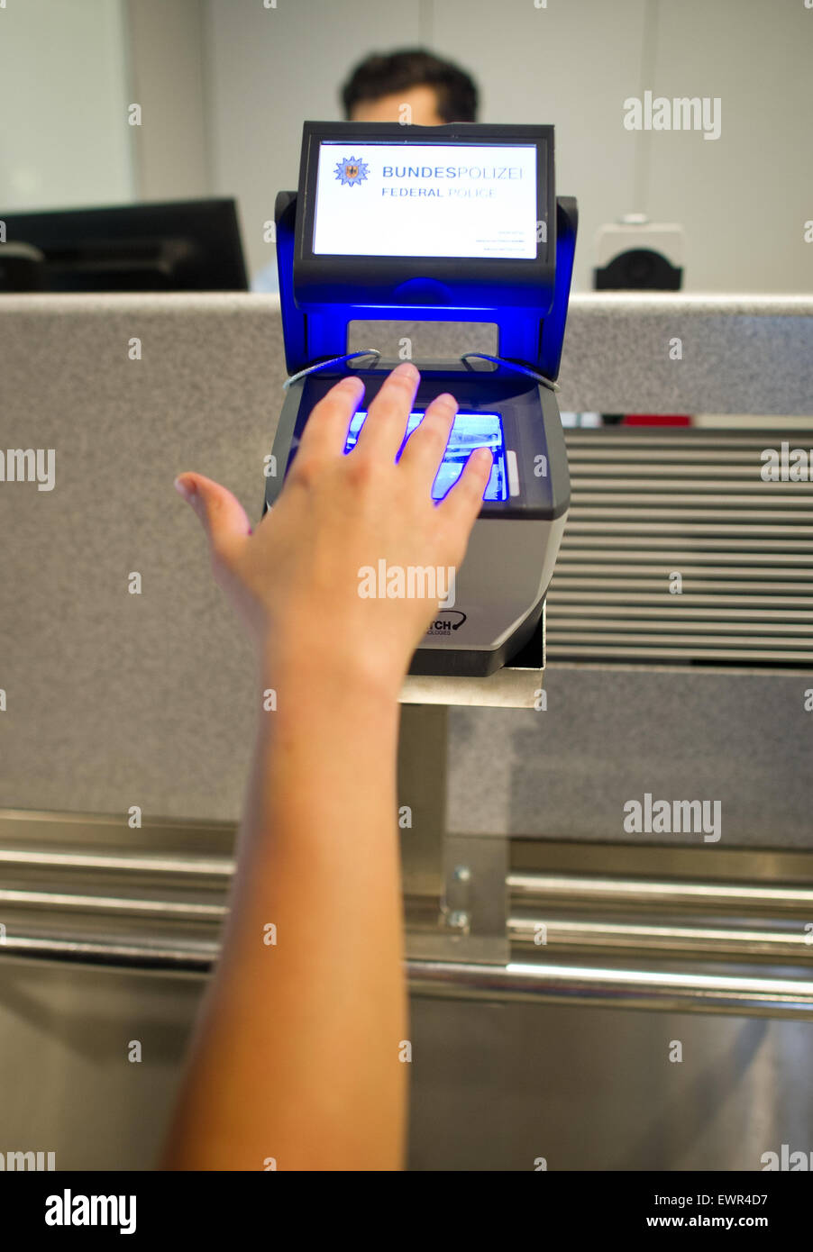 A female passenger places four fingers on a scanner of the 'Smart ...