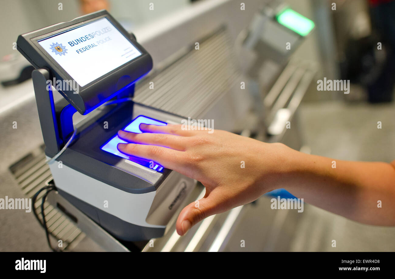 A female passenger places four fingers on a scanner of the 'Smart ...