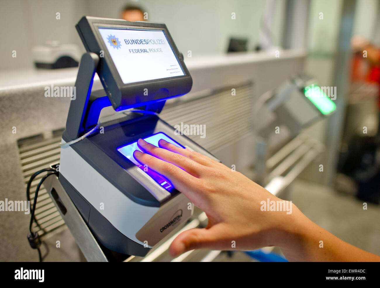 A female passenger places four fingers on a scanner of the 'Smart ...