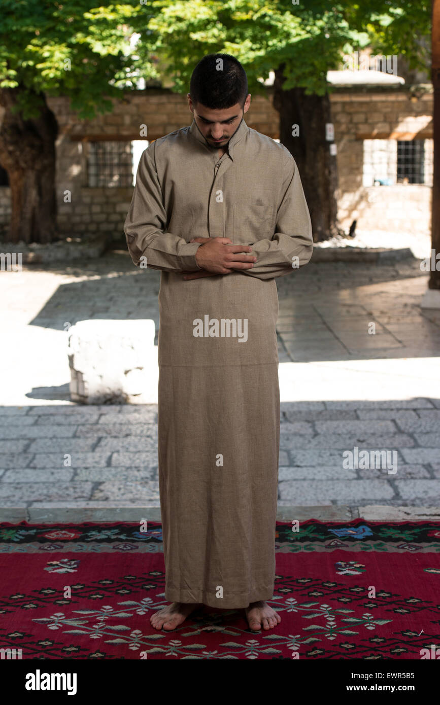Young Muslim Man Making Traditional Prayer To God While Wearing A ...