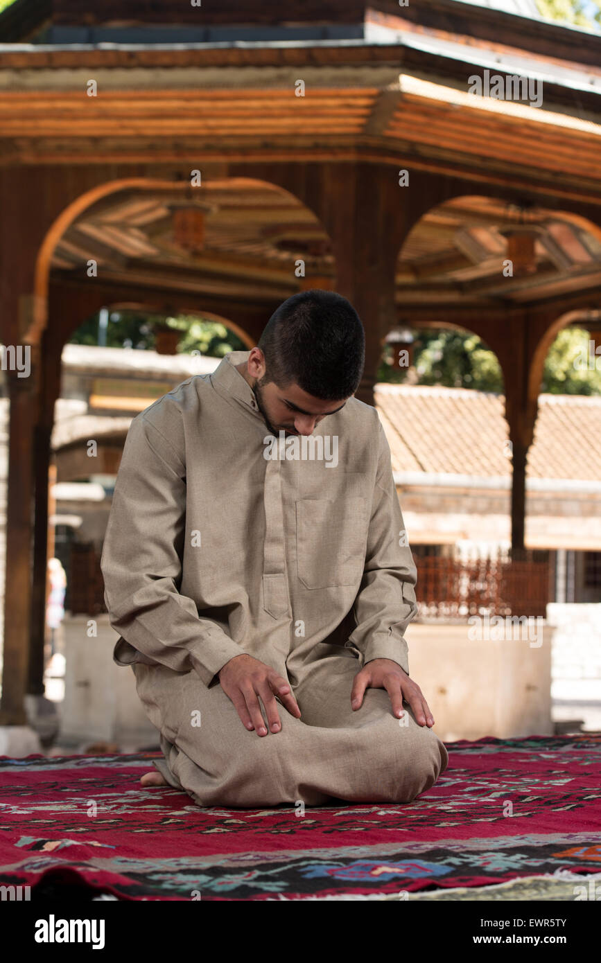 Young Muslim Man Making Traditional Prayer To God While Wearing A ...