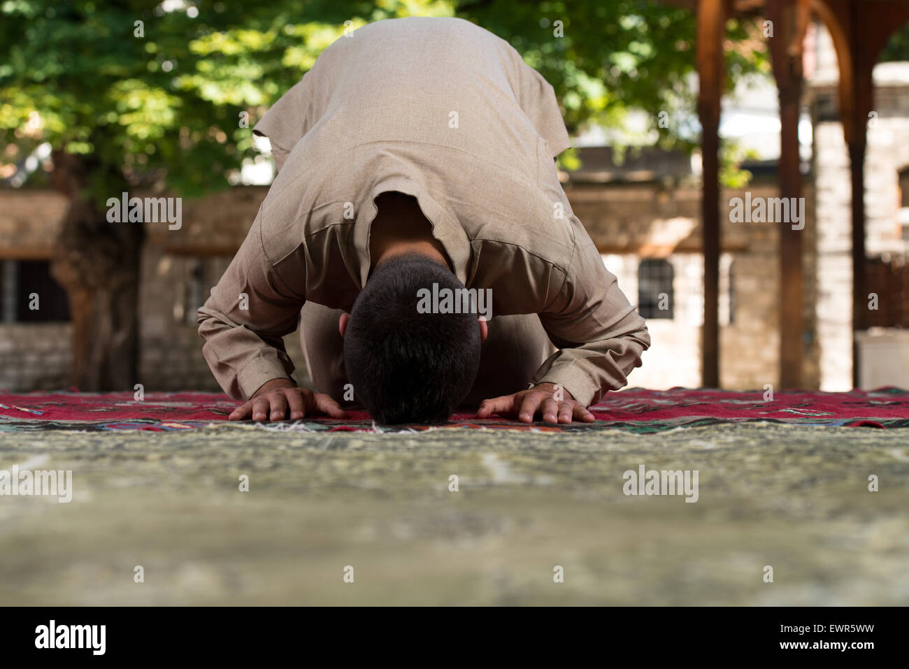 Young Muslim Man Making Traditional Prayer To God While Wearing A ...