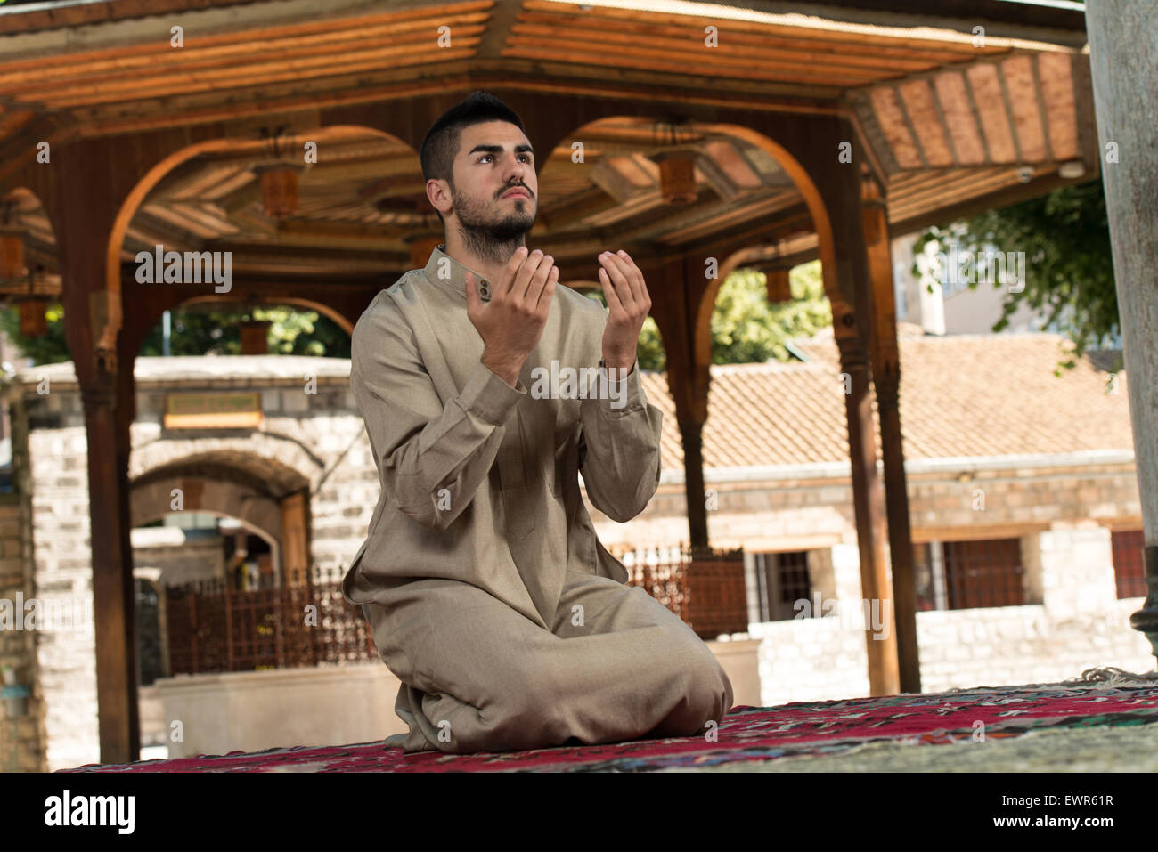 Young Muslim Man Making Traditional Prayer To God While Wearing A ...