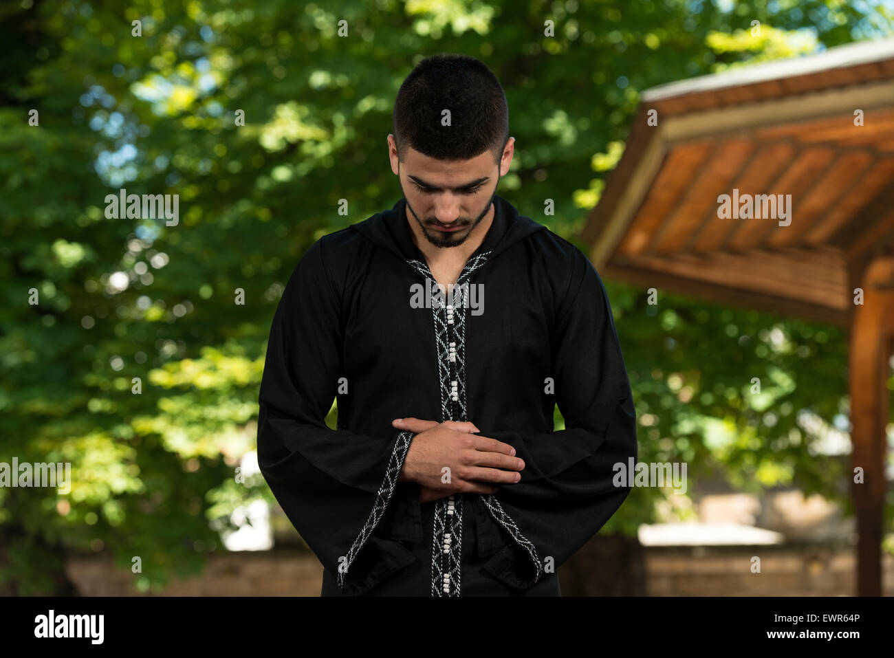 Young Muslim Man Making Traditional Prayer To God While Wearing A ...