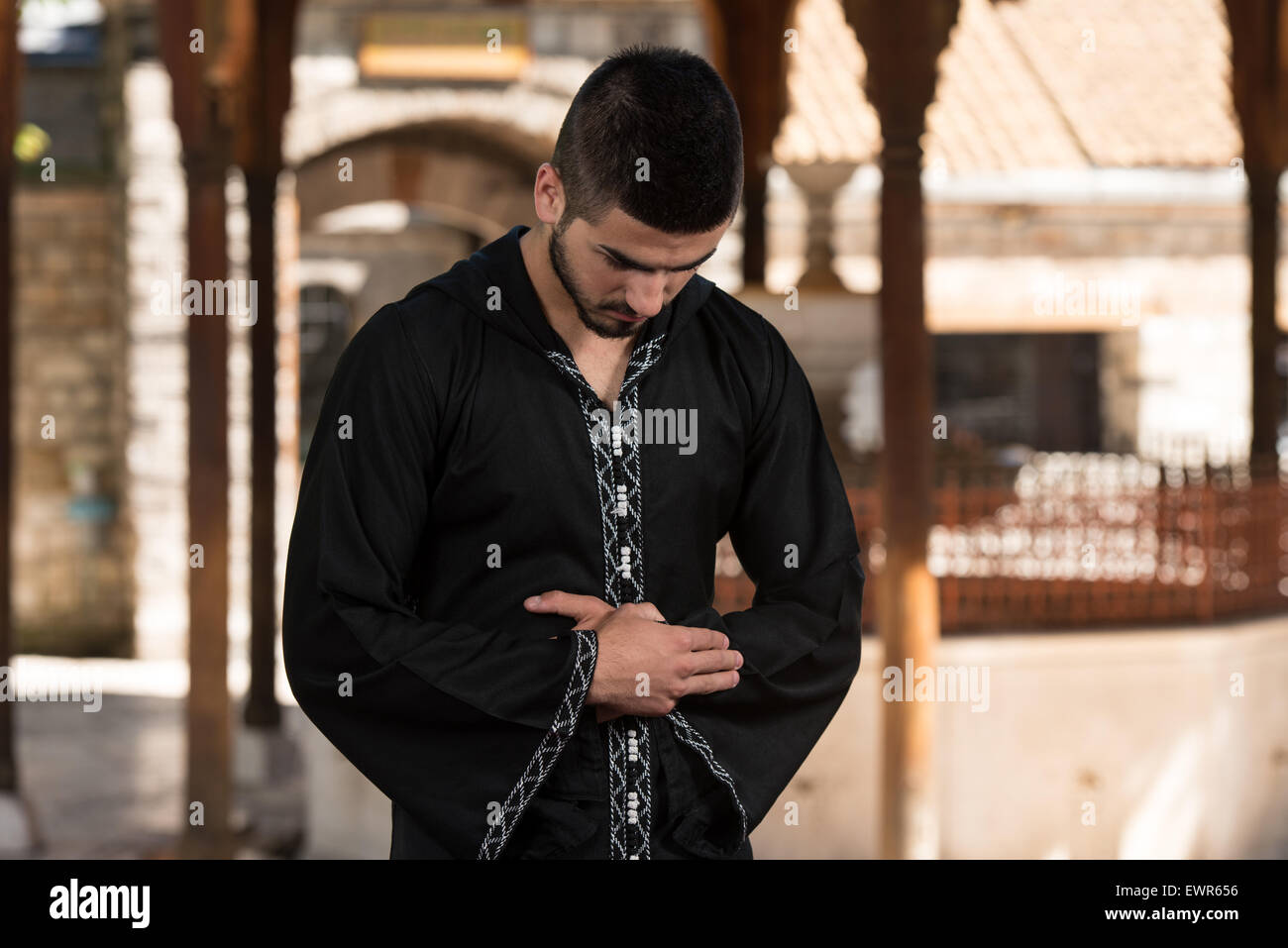 Young Muslim Man Making Traditional Prayer To God While Wearing A ...
