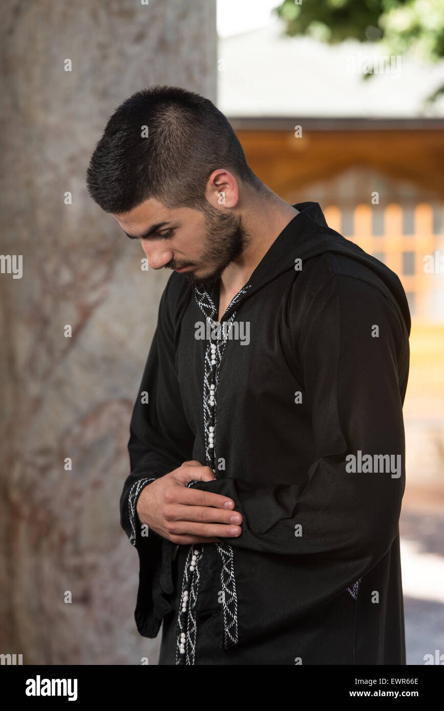 Young Muslim Man Making Traditional Prayer To God While Wearing A ...