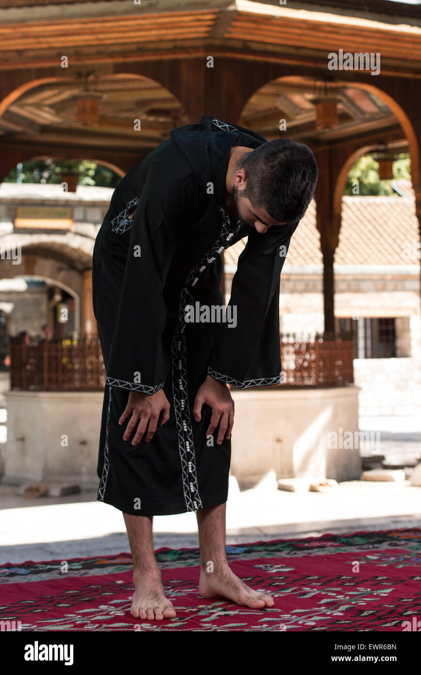 Young Muslim Man Making Traditional Prayer To God While Wearing A ...