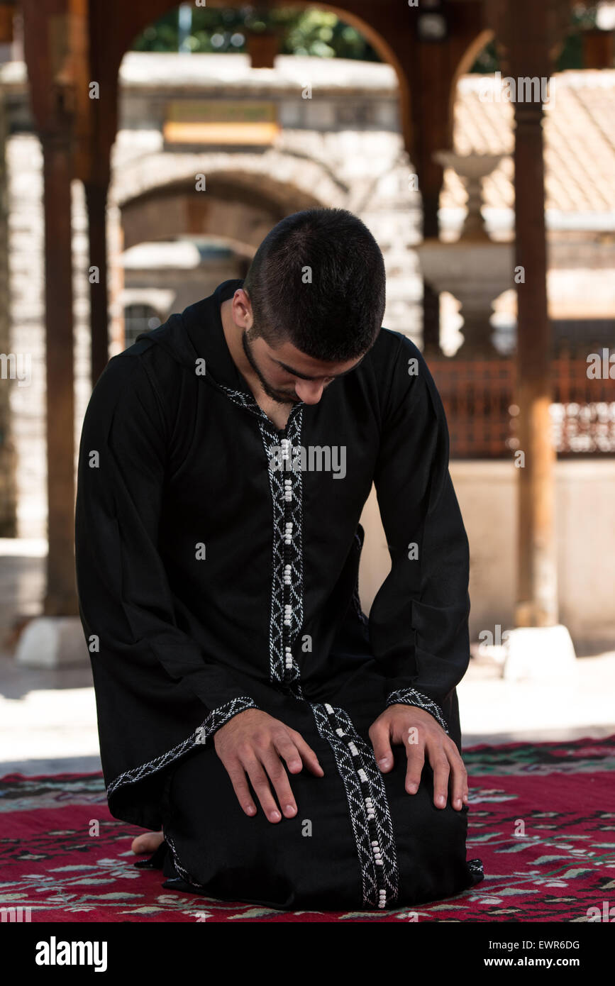 Young Muslim Man Making Traditional Prayer To God While Wearing A ...