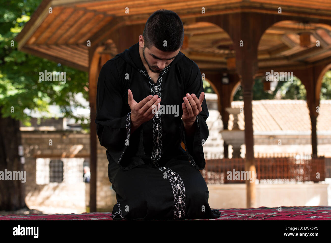 Young Muslim Man Making Traditional Prayer To God While Wearing A ...
