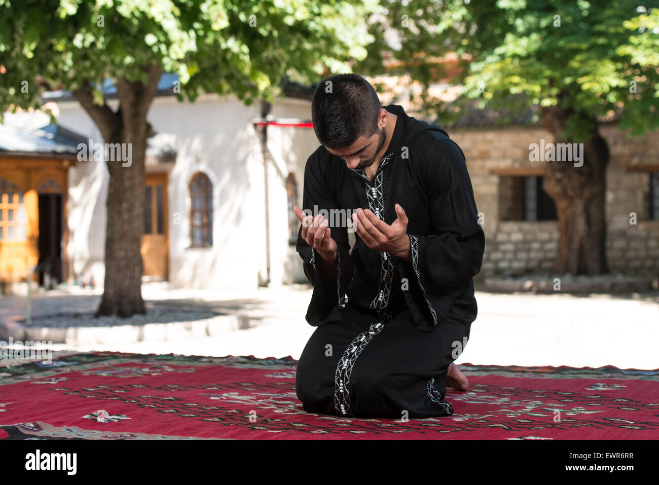 Young Muslim Man Making Traditional Prayer To God While Wearing A ...