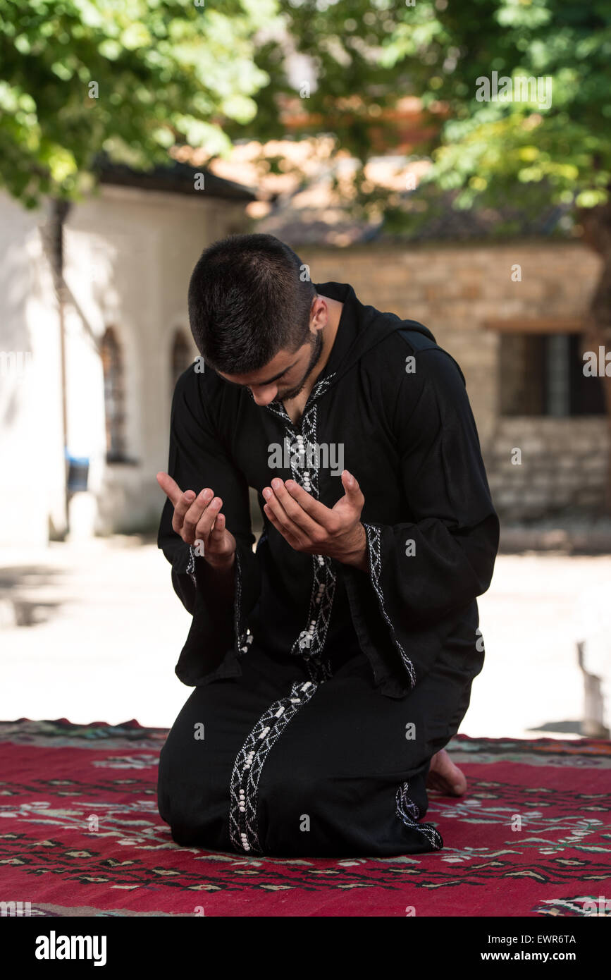 Young Muslim Man Making Traditional Prayer To God While Wearing A ...