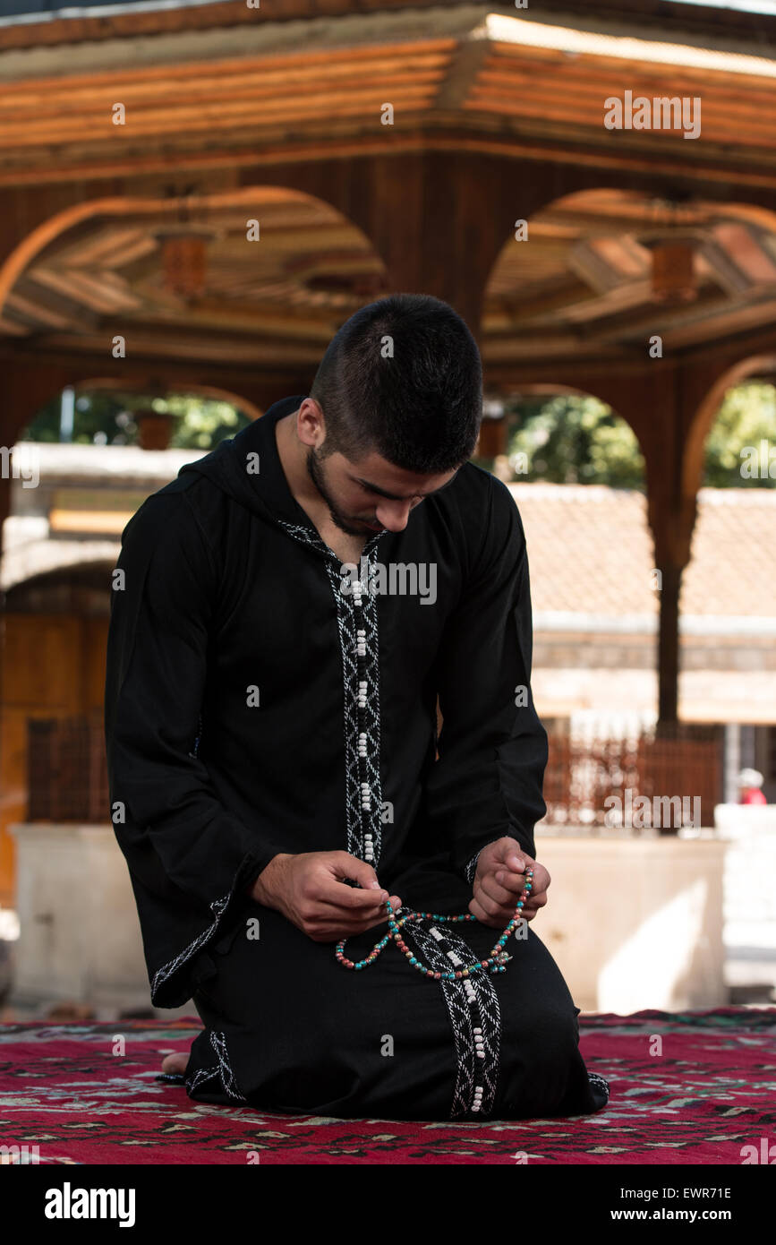 Young Muslim Man Making Traditional Prayer To God While Wearing A ...