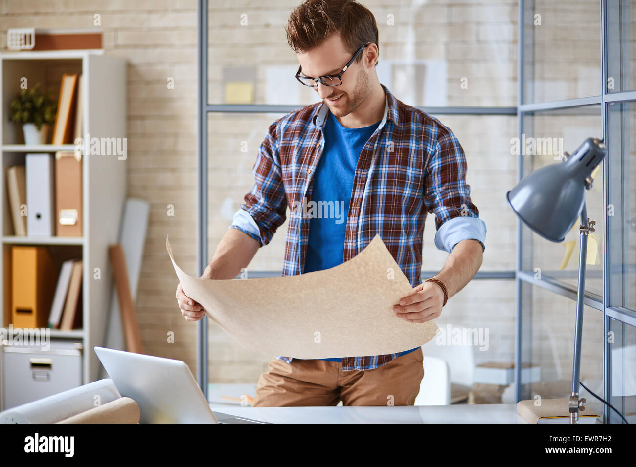 Handsome architect looking at sketch in his hands Stock Photo - Alamy
