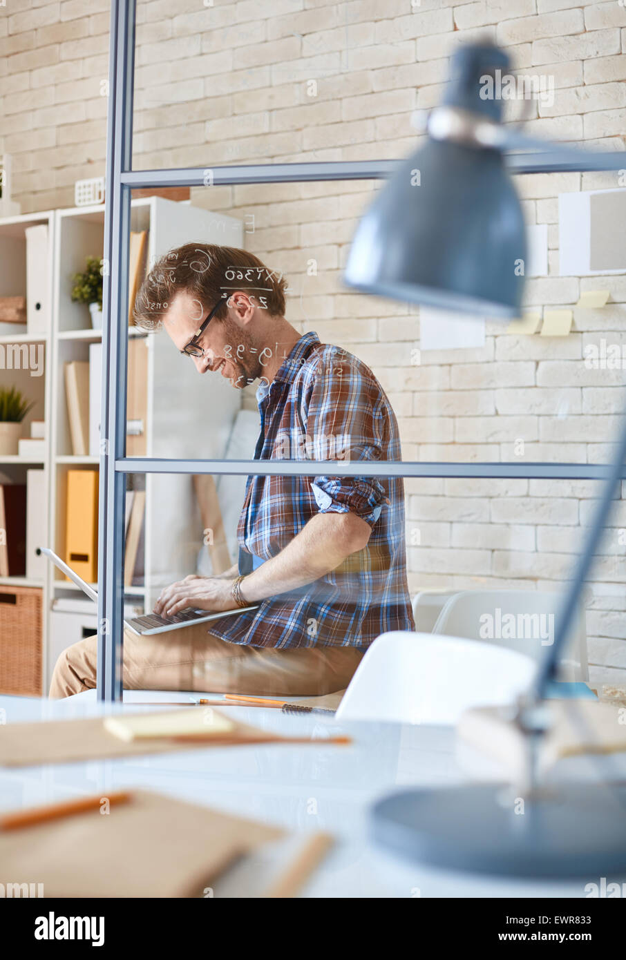 Happy young businessman typing in office Stock Photo - Alamy
