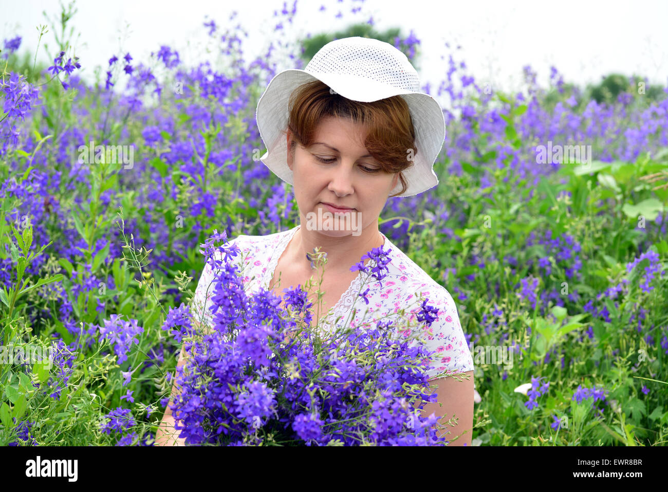 WoWoman with a bouquet of wild flowers on the lawnman with a bouquet of ...