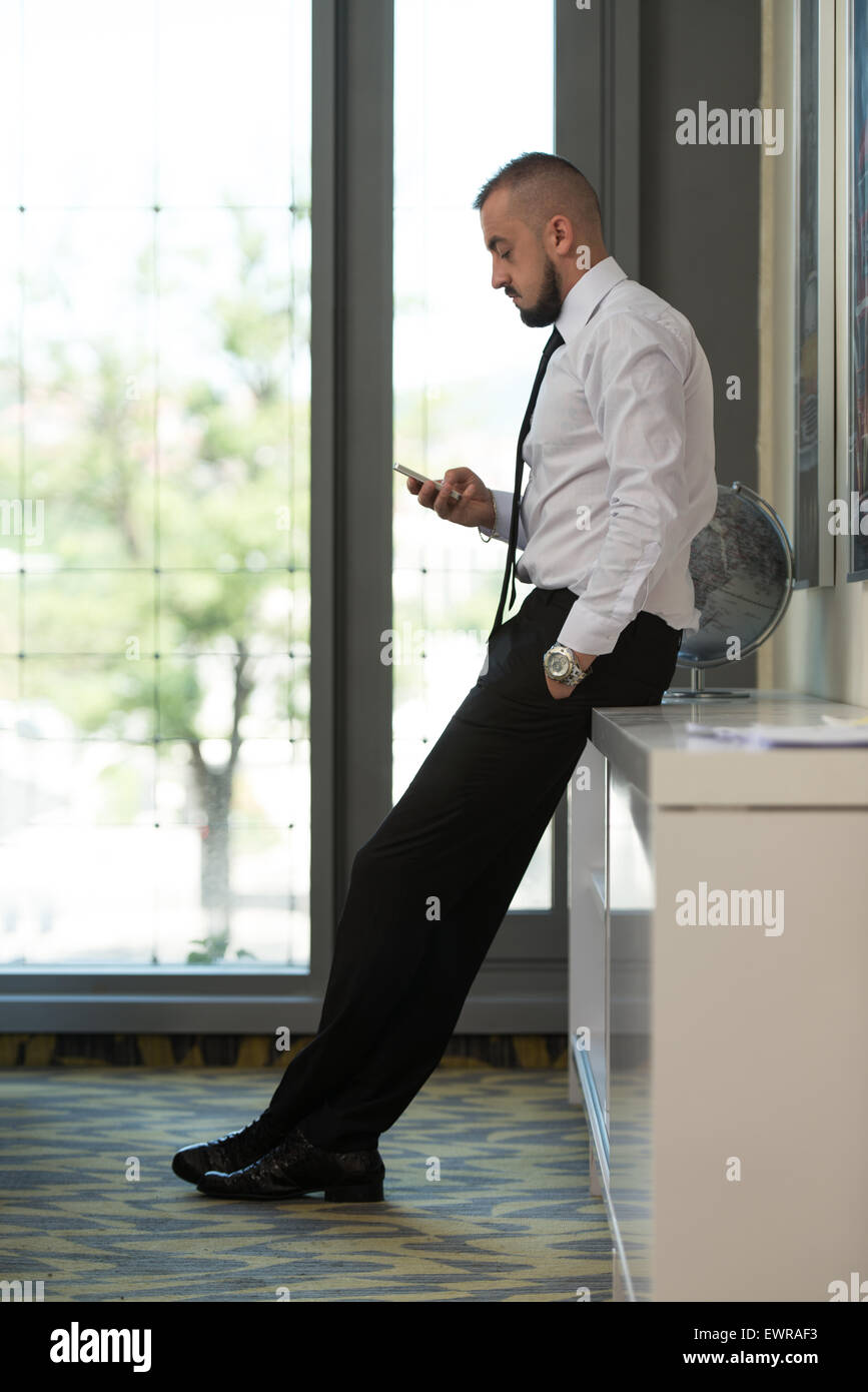 Business Man Reading Text Message On A Mobile In A Modern Office Stock ...