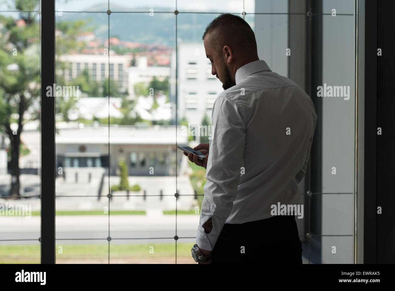 Business Man Reading Text Message On A Mobile In A Modern Office Stock ...