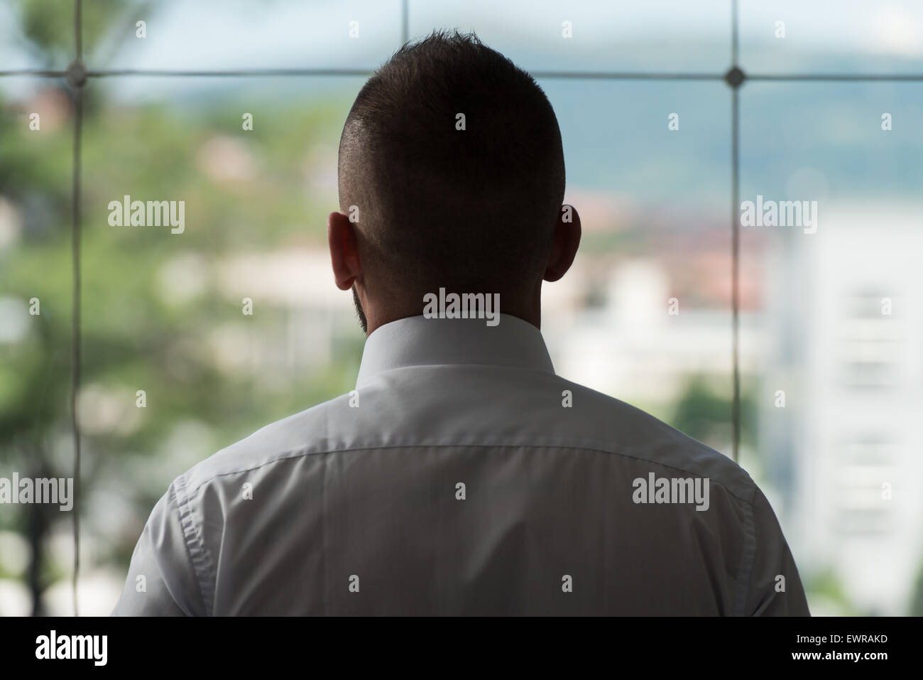 Young Businessman Looking Out Office Window Pondering Future Stock ...