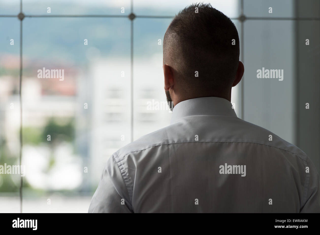 Young Businessman Looking Out Office Window Pondering Future Stock ...