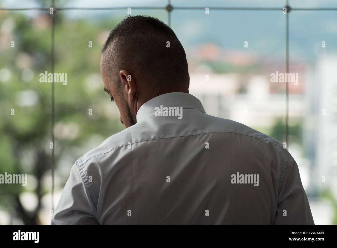 Young Businessman Looking Out Office Window Pondering Future Stock ...