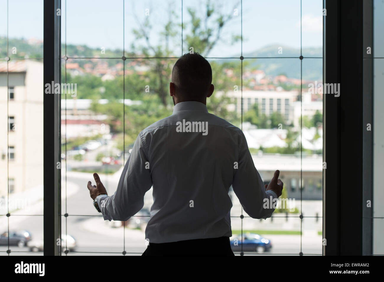 Young Businessman Looking Out Office Window Pondering Future Stock ...