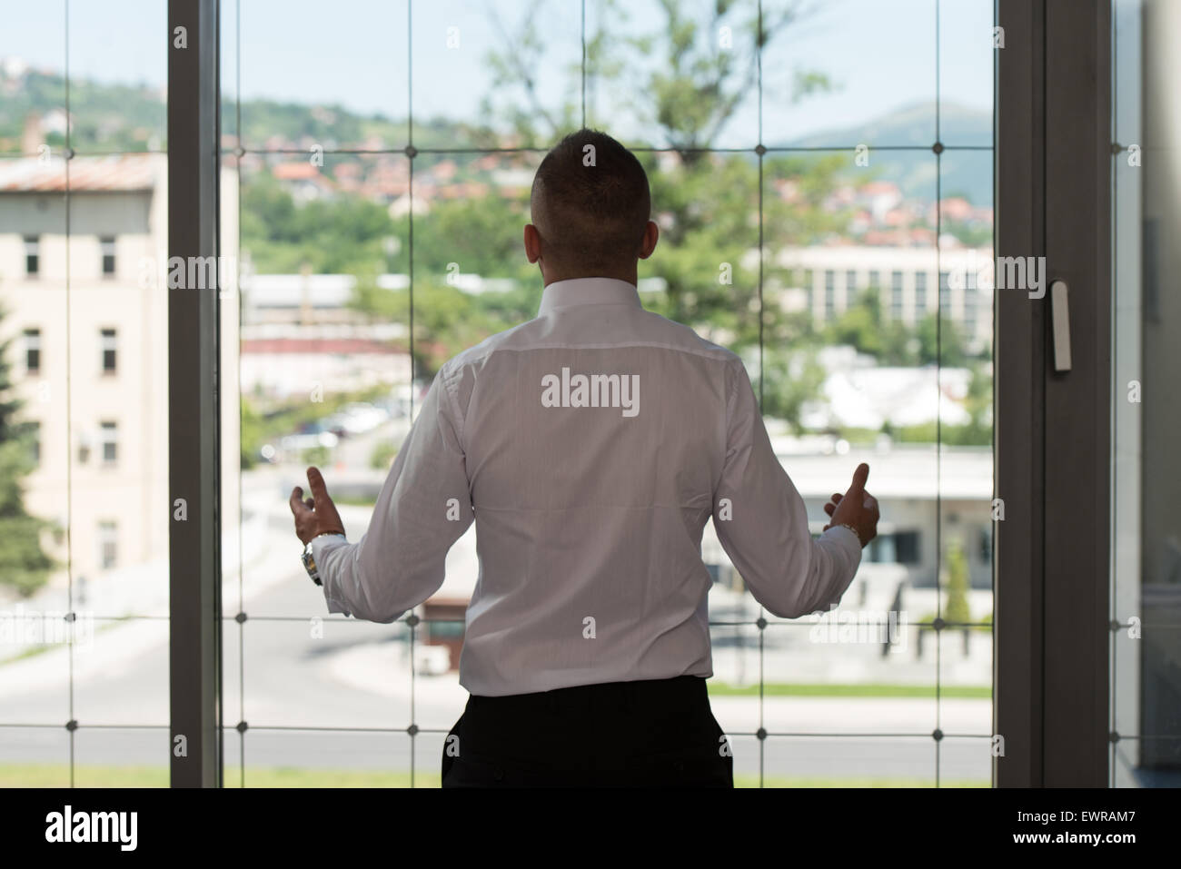 Young Businessman Looking Out Office Window Pondering Future Stock ...