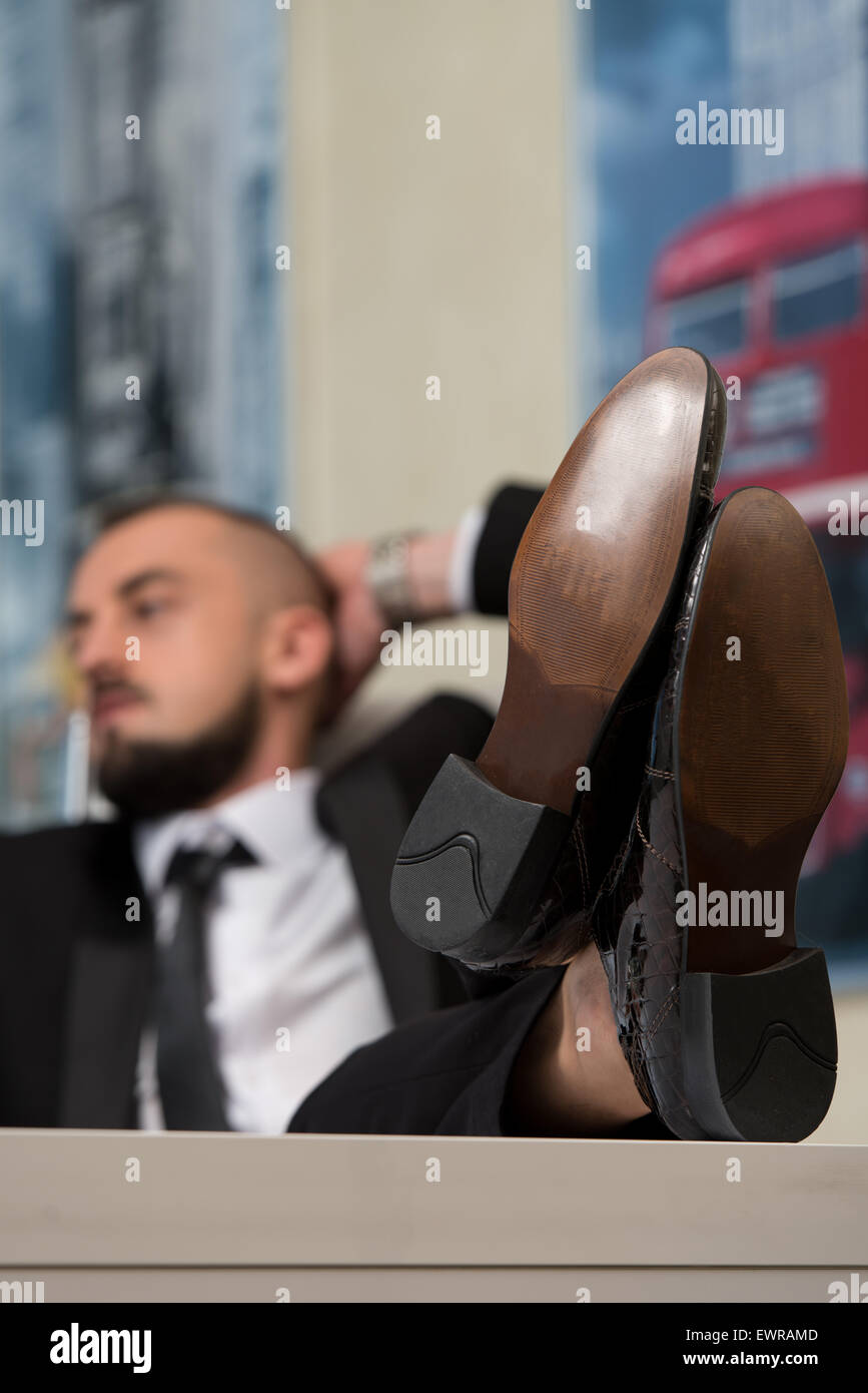 Relaxed Businessman Kicks Back With His Feet Up Stock Photo - Alamy