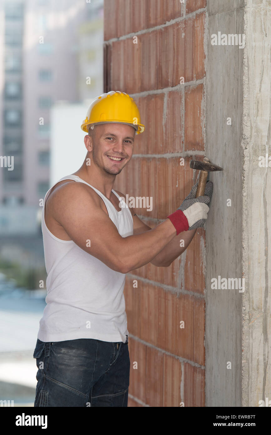 A Handsome Construction Man Using A Hammer To Nail Together Wood Stock ...