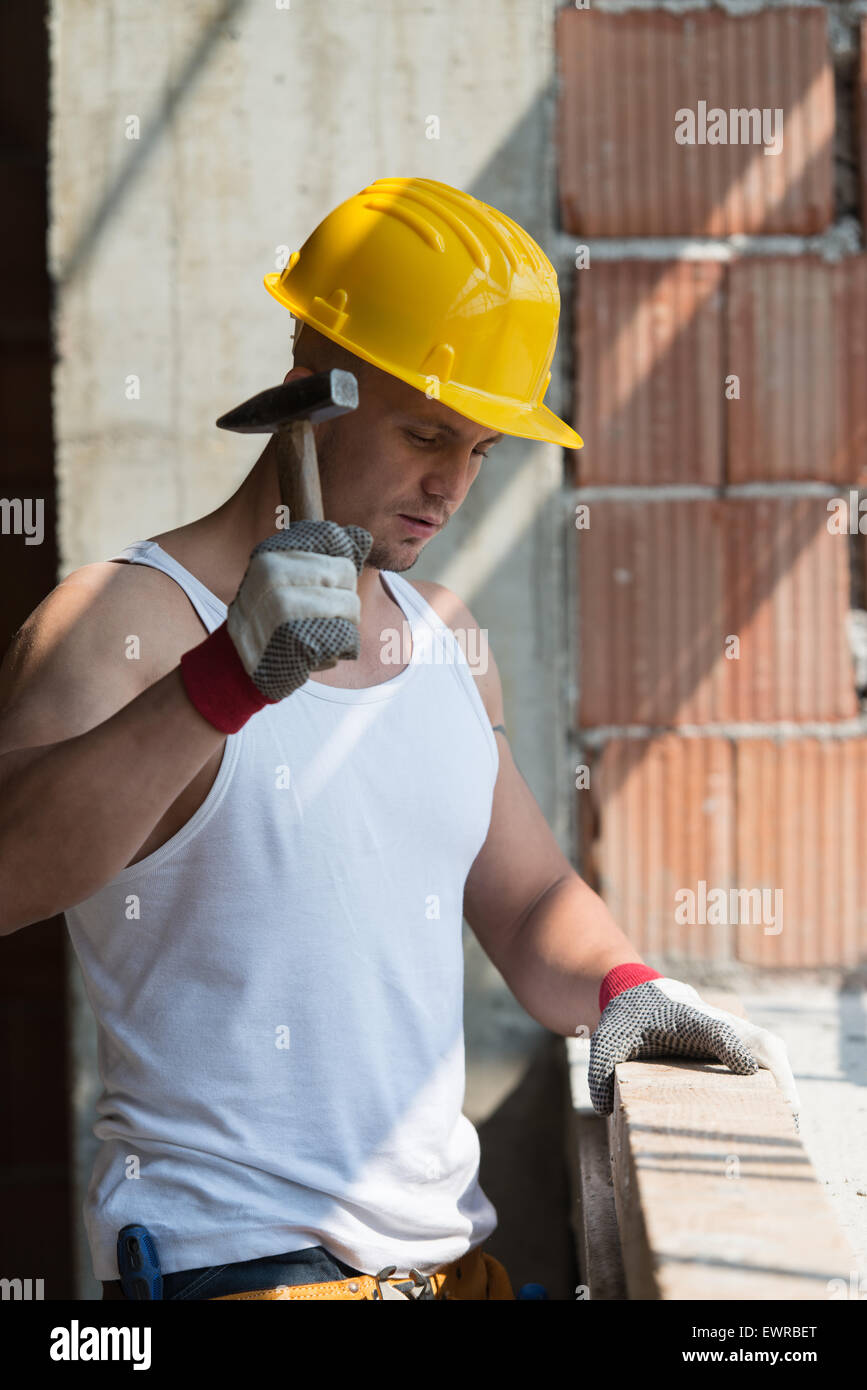 A Handsome Construction Man Using A Hammer To Nail Together Wood Stock ...