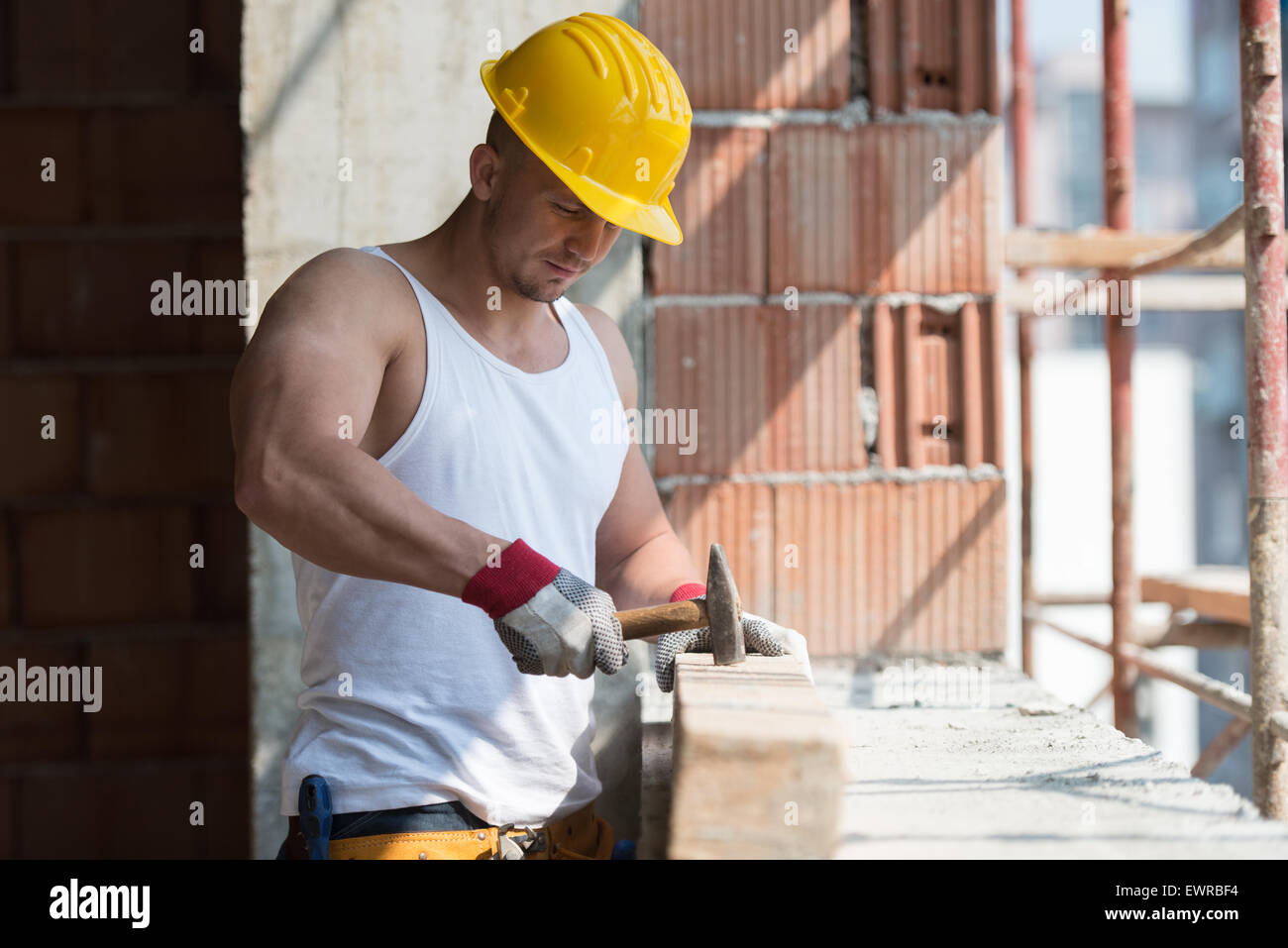 A Handsome Construction Man Using A Hammer To Nail Together Wood Stock ...