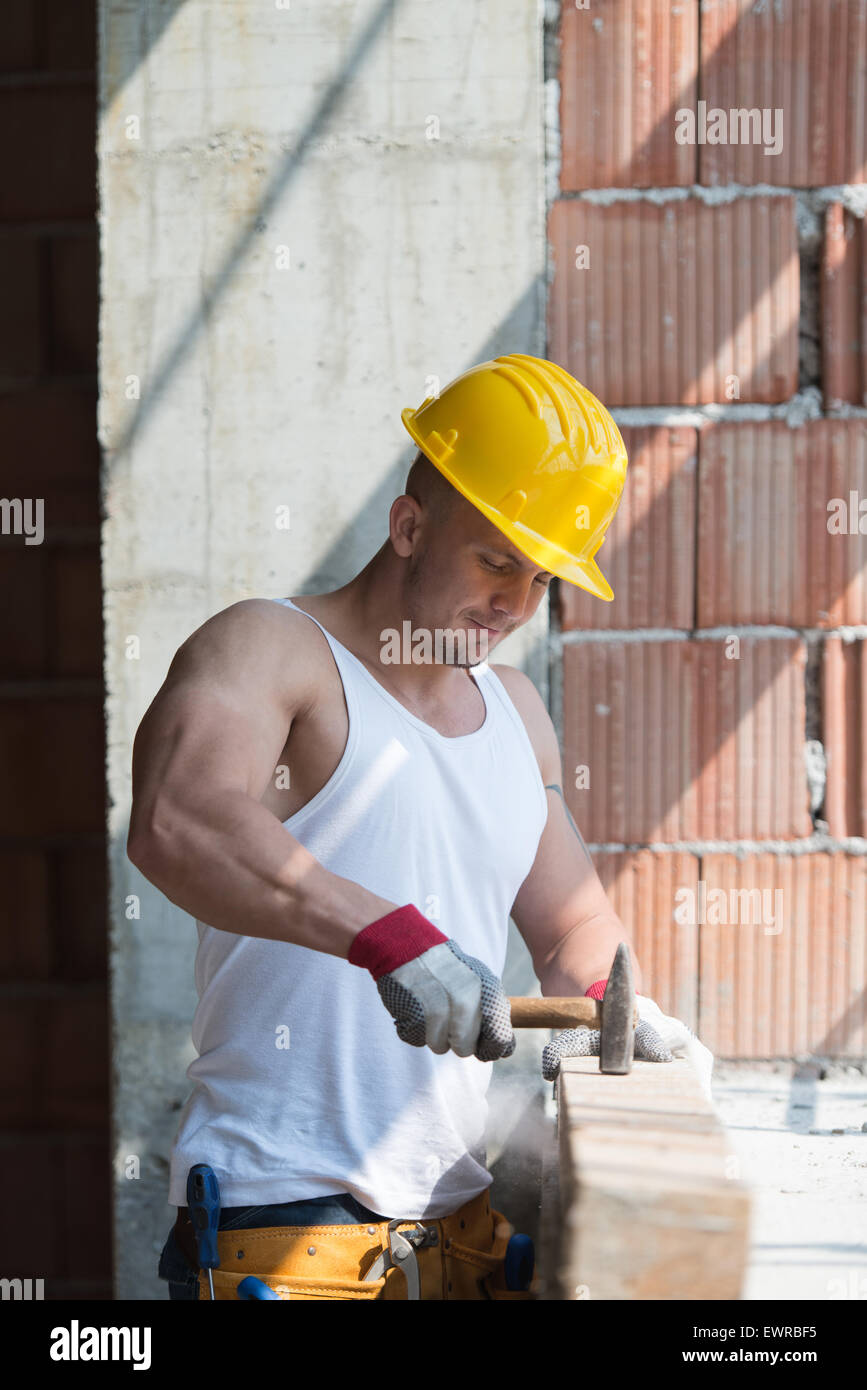 A Handsome Construction Man Using A Hammer To Nail Together Wood Stock ...