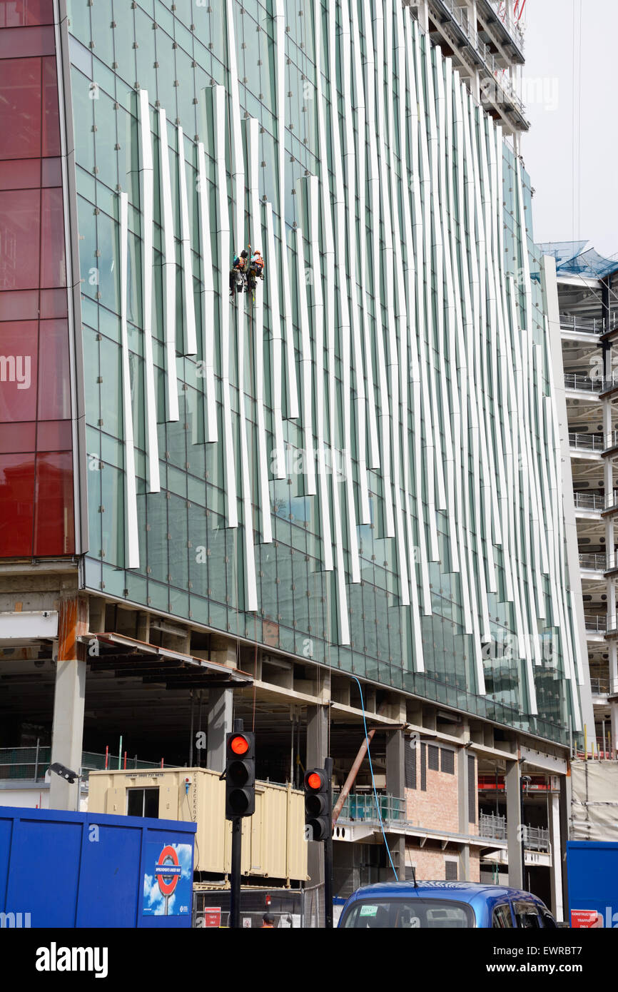 Worker on rope, cladding new building at Victoria, London. England ...