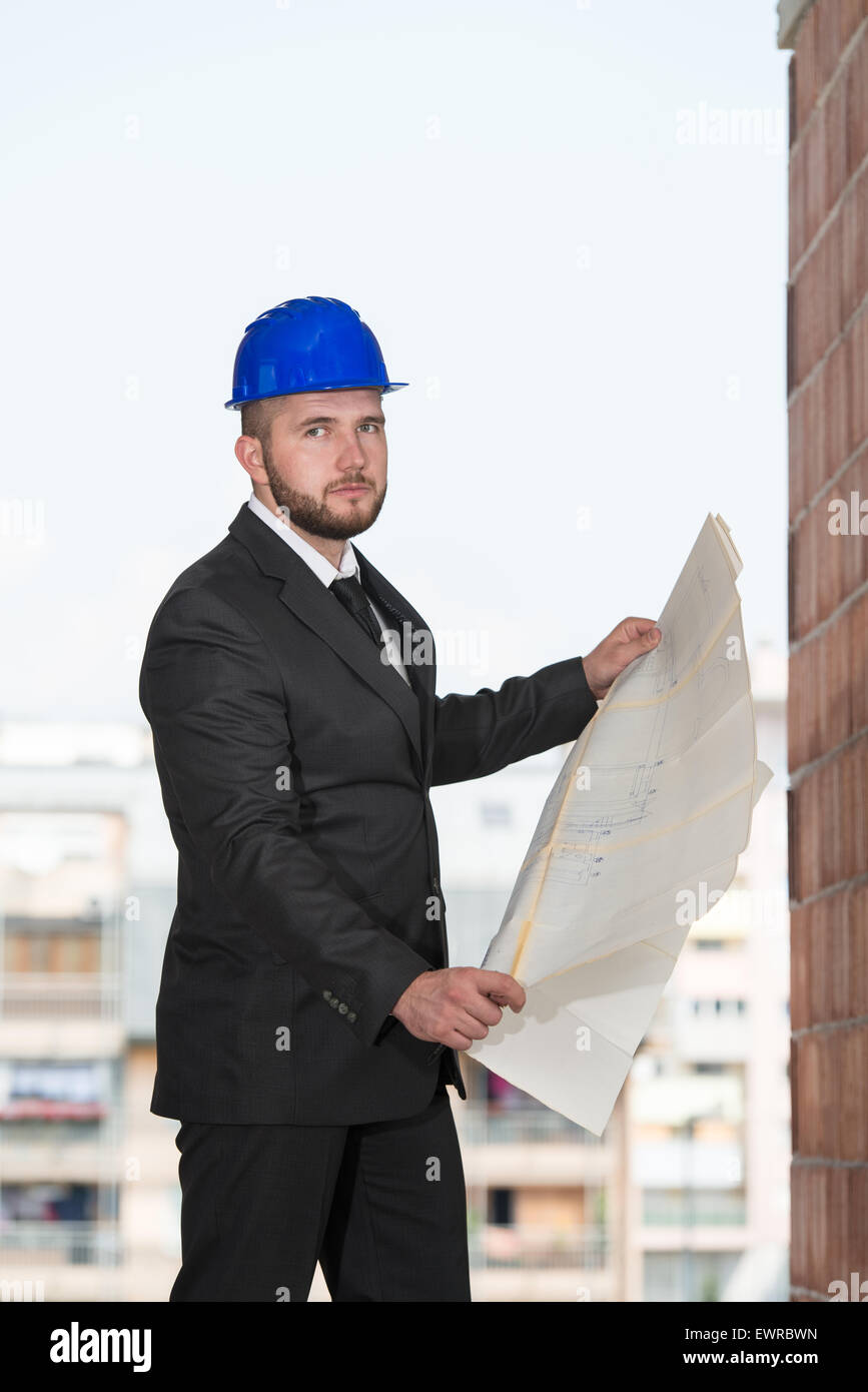 Portrait Of Construction Master With Blue Helmet And Blueprint In Hands ...