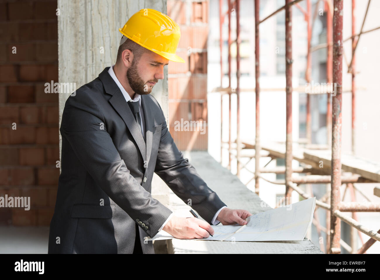 Portrait Of Construction Master With Yellow Helmet And Blueprint In ...