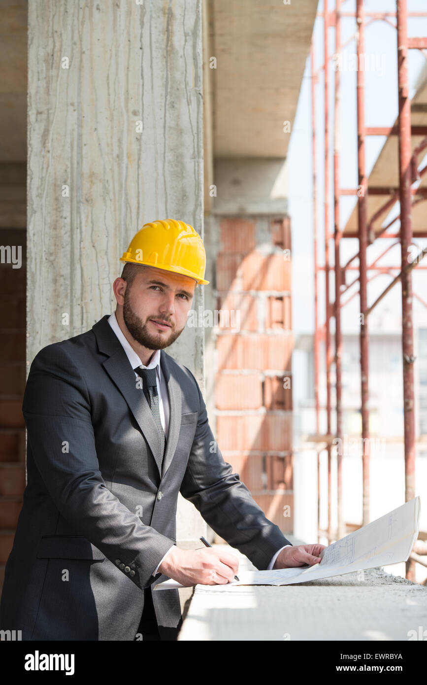 Portrait Of Construction Master With Yellow Helmet And Blueprint In ...