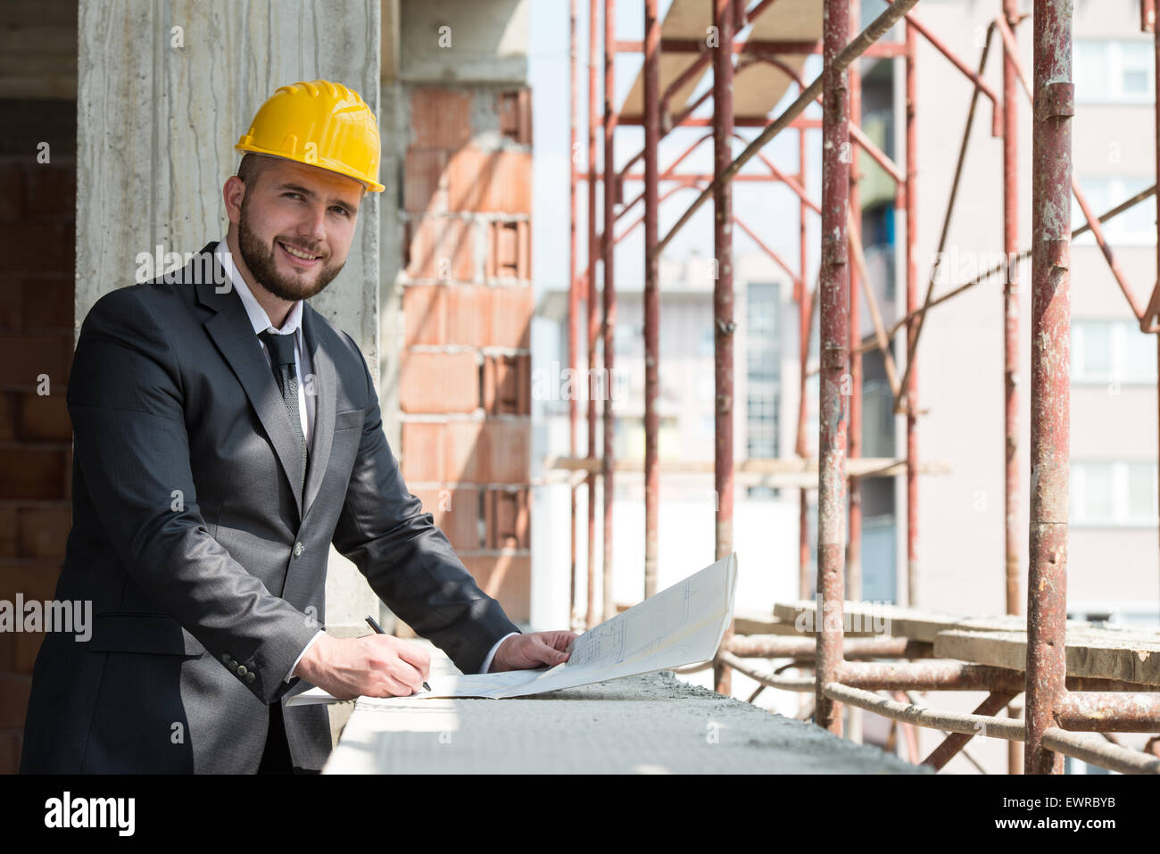 Portrait Of Construction Master With Yellow Helmet And Blueprint In ...