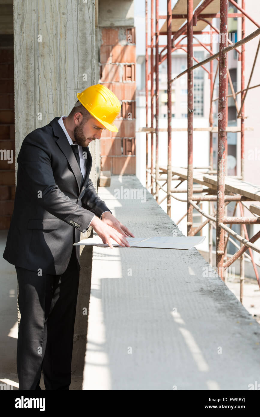 Portrait Of Construction Master With Yellow Helmet And Blueprint In ...