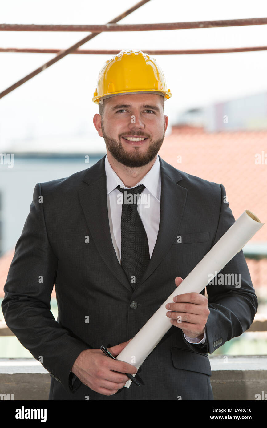 Portrait Of Construction Master With Yellow Helmet And Blueprint In ...