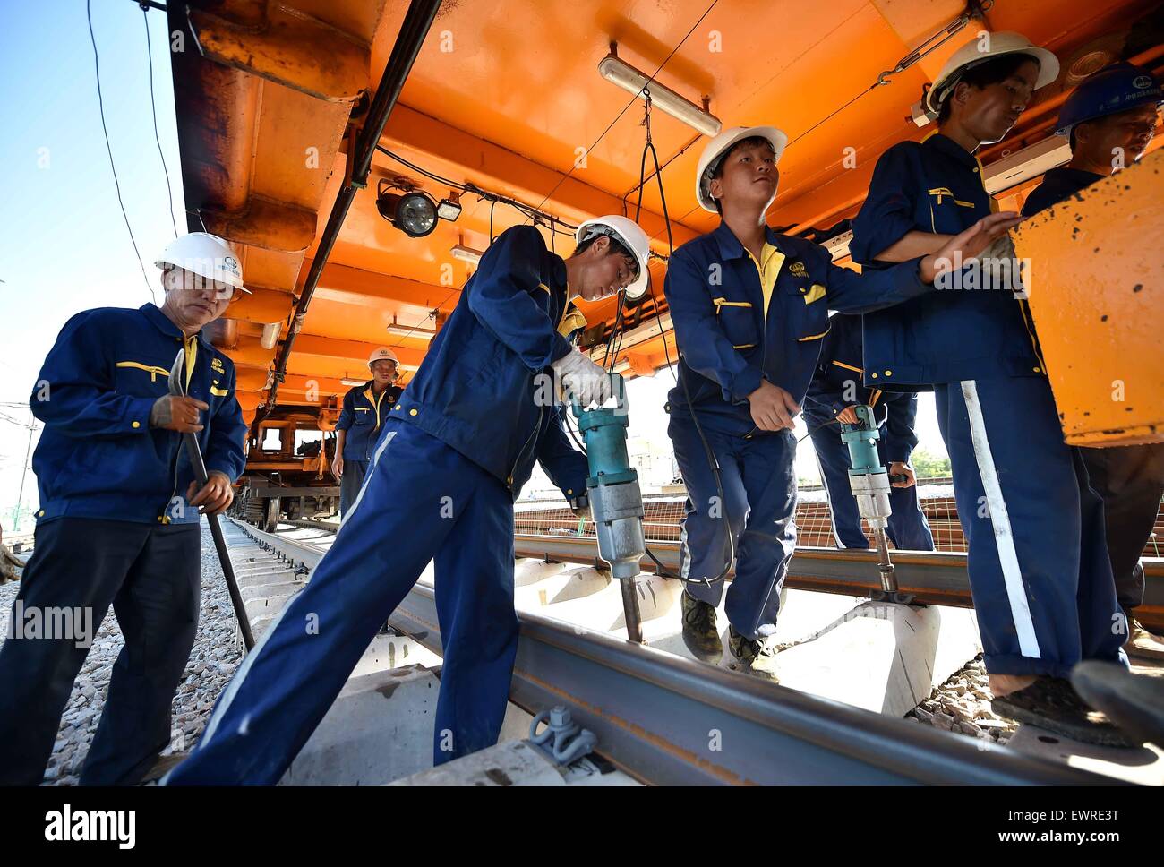 Haikou. 30th June, 2015. Workers lay the last section of steel rail on ...