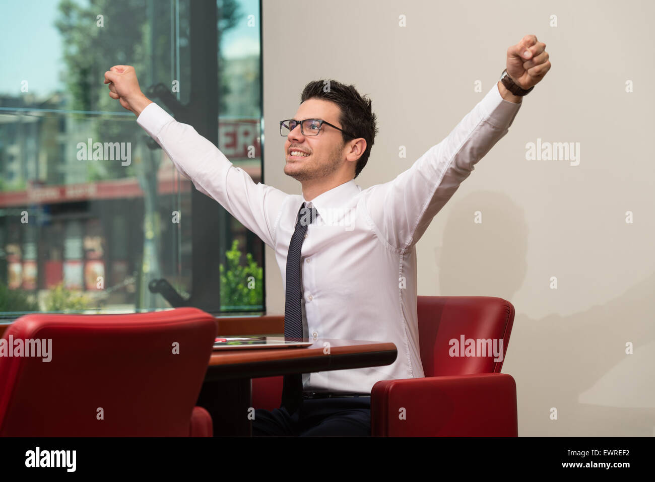Successful Business Man With Arms Up At The Office Stock Photo - Alamy