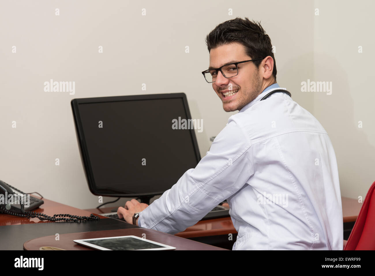 Handsome Doctor Looking At His Computer Monitor In His Office Stock ...