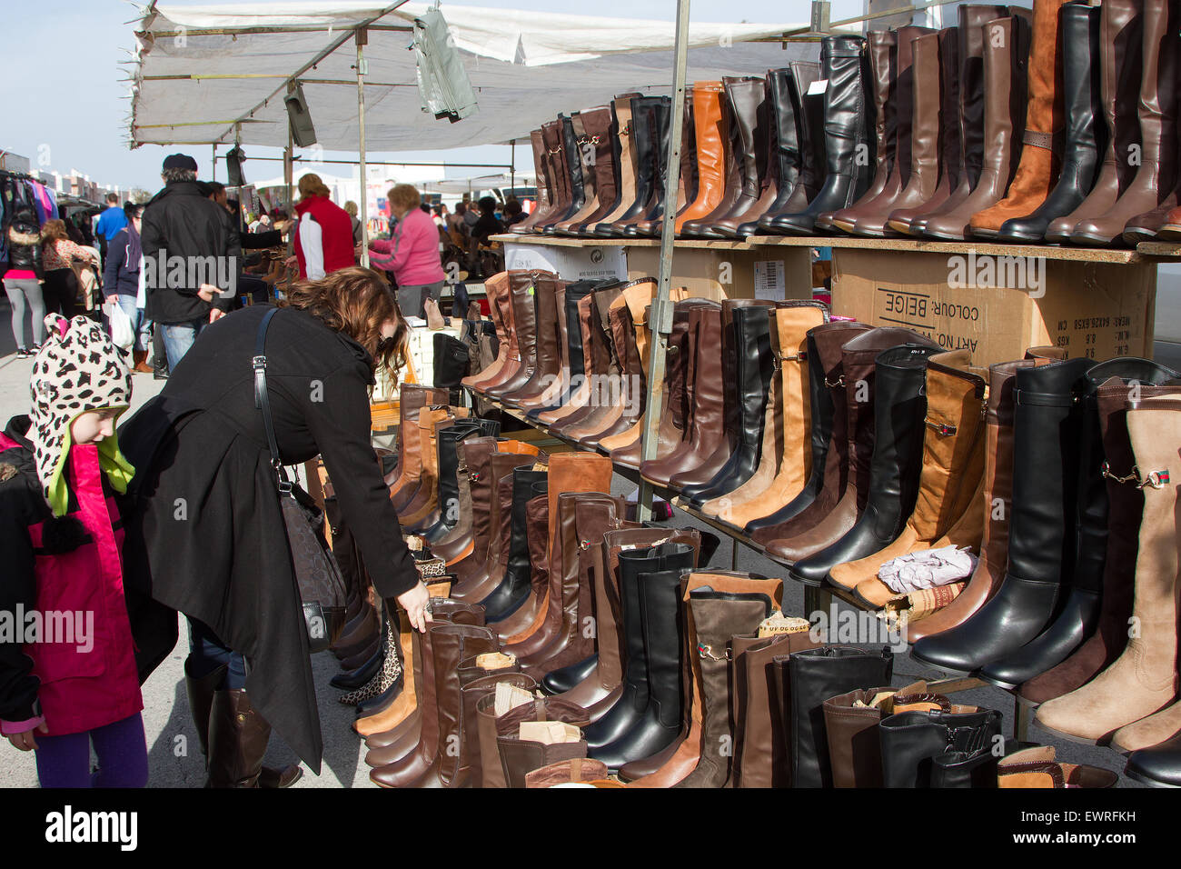 Boot shopping for a mother and daughter at an outdoor bazaar in Rota ...