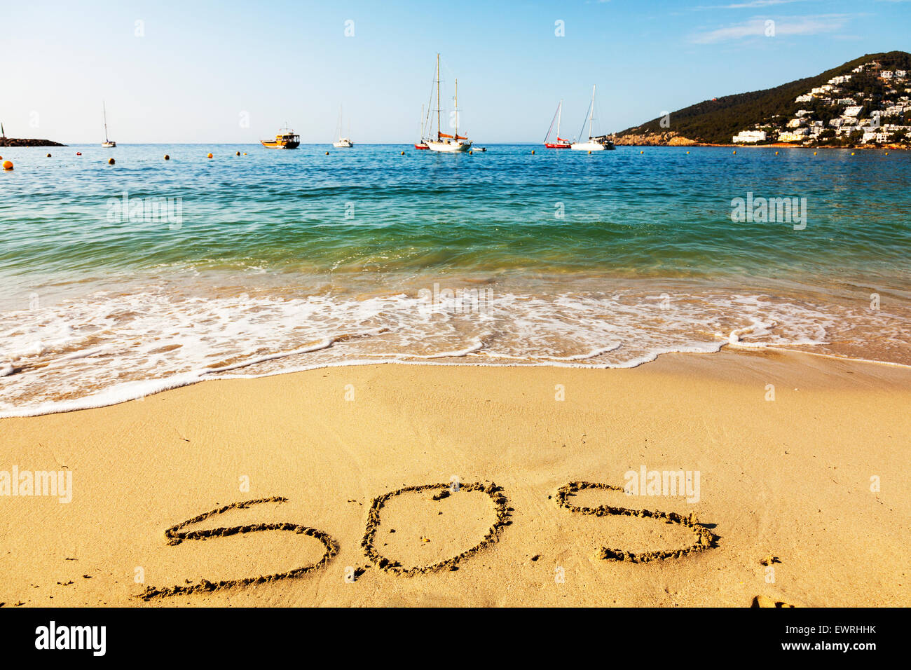 SOS save our souls word in sand written on beach rescue island ...