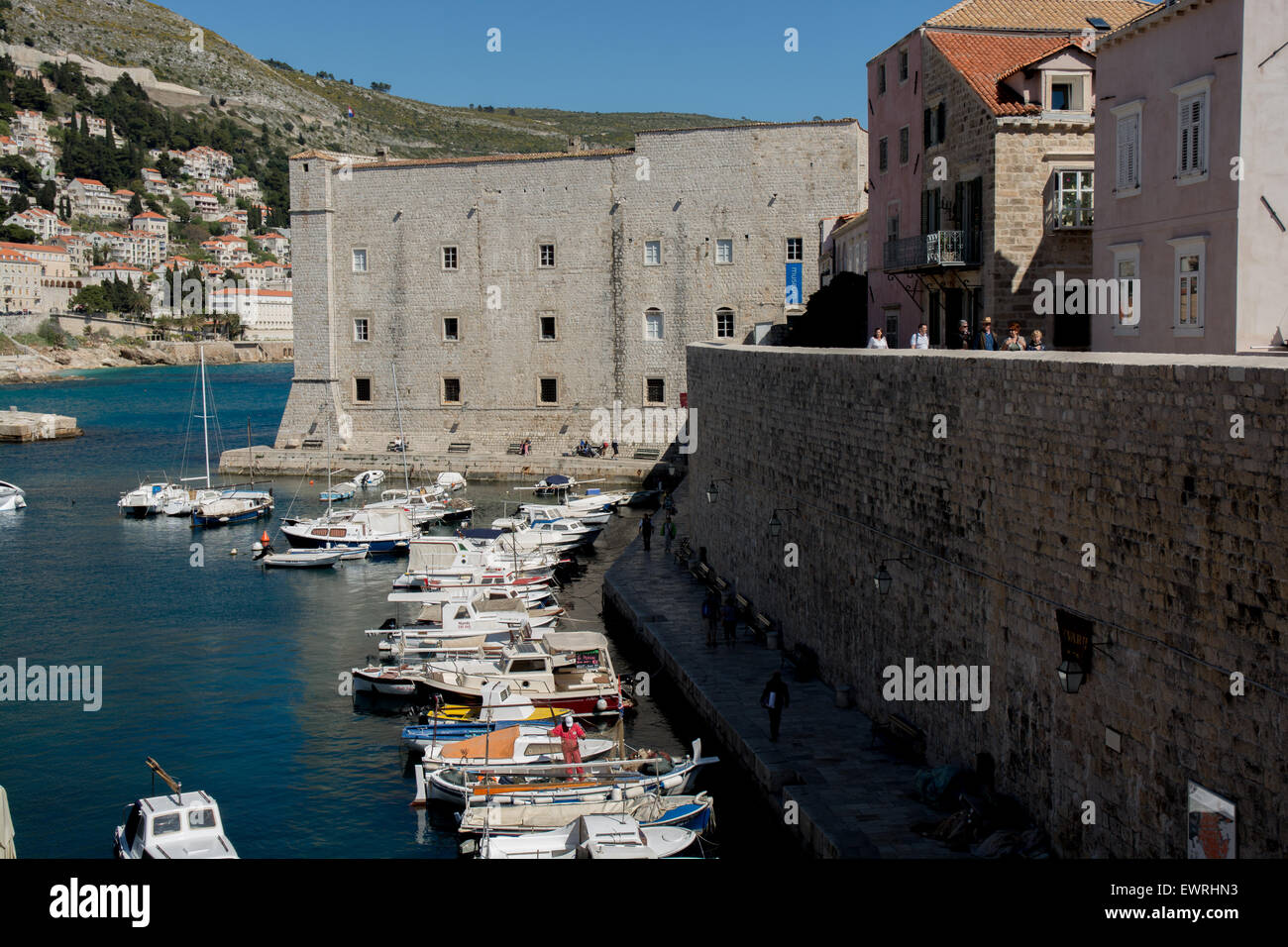 old city wall alongside port with st. john's fort in background ...